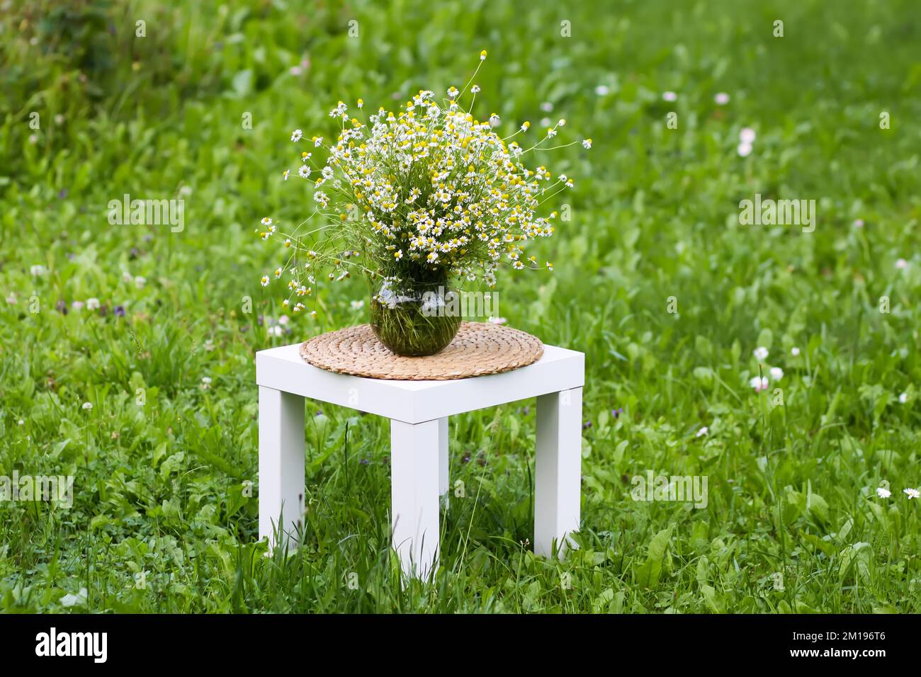 Bouquet of summer flowers on table on patio yard. Fresh wildflowers in ...