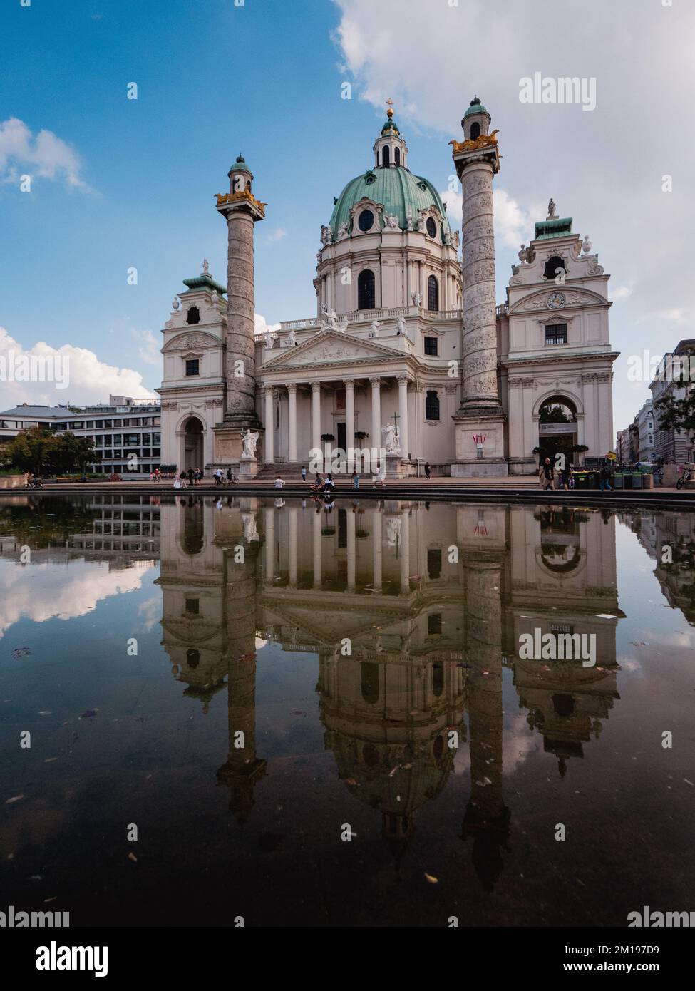A vertical shot of the Karlskirche church near the water in Karlsplatz ...
