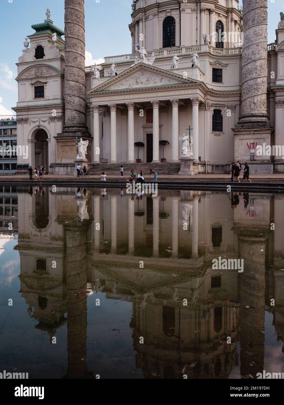 A vertical shot of the Karlskirche church near the water in Karlsplatz ...