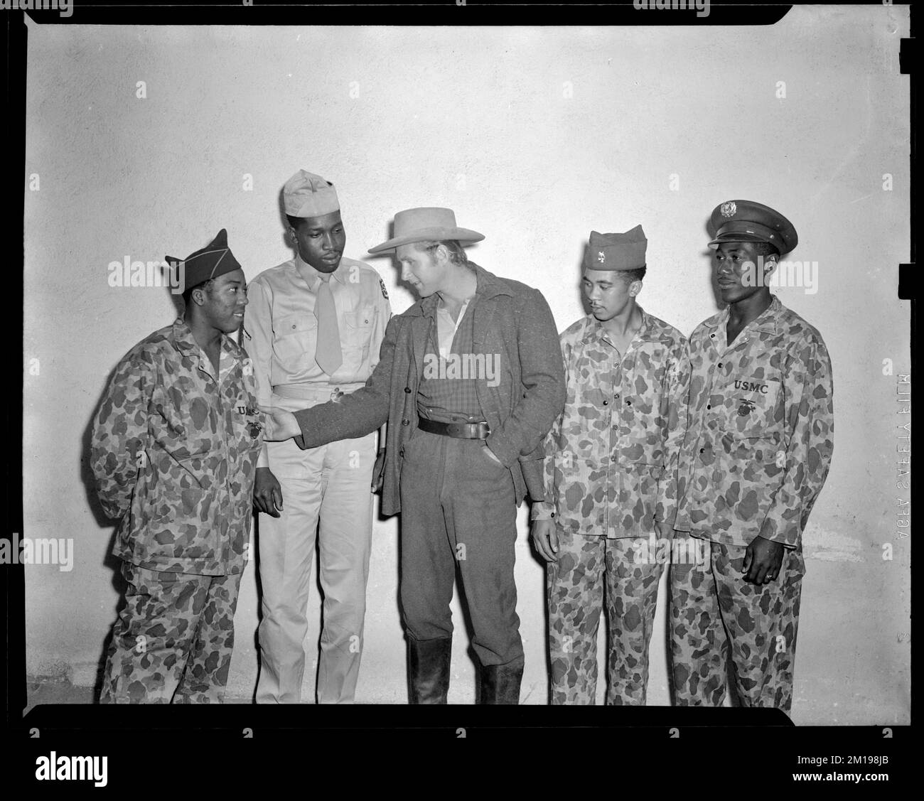 Three men in 'Jungleers' uniform pose with a man in military uniform ...