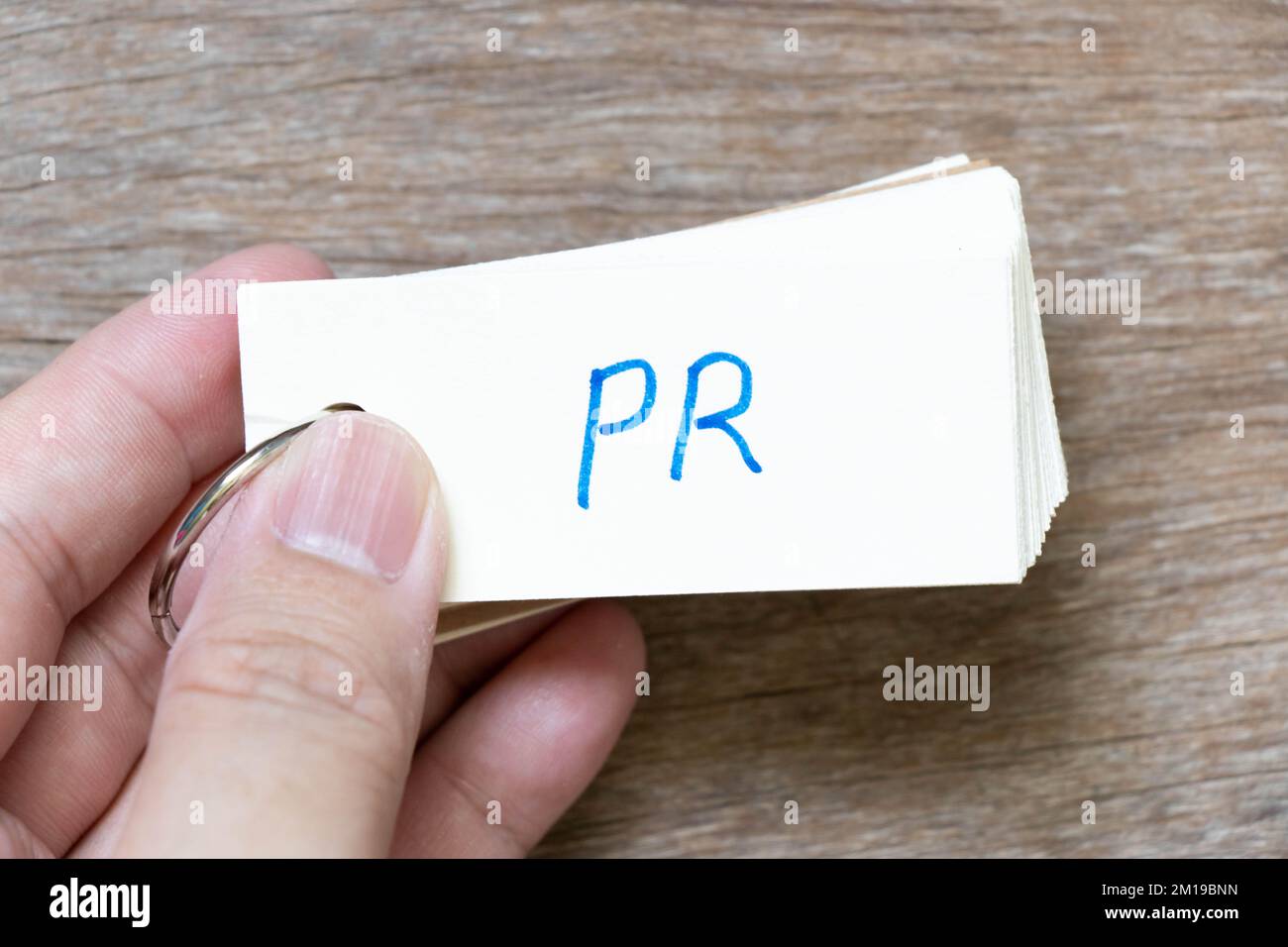 Hand hold flash card with handwriting in word PR (Abbreviation of ...