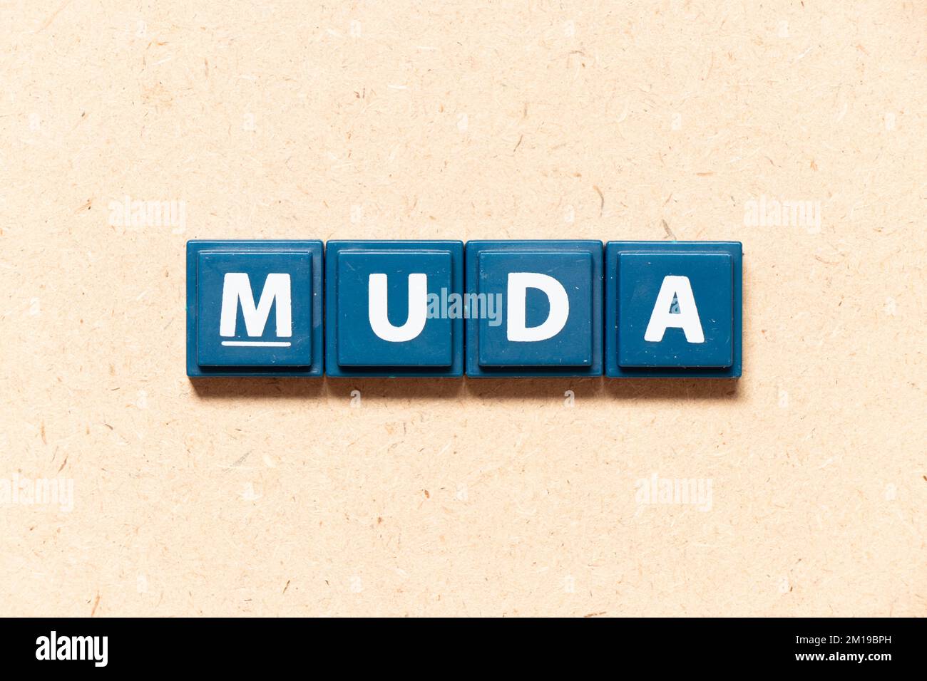 Tile letter in english word muda on wood background Stock Photo - Alamy