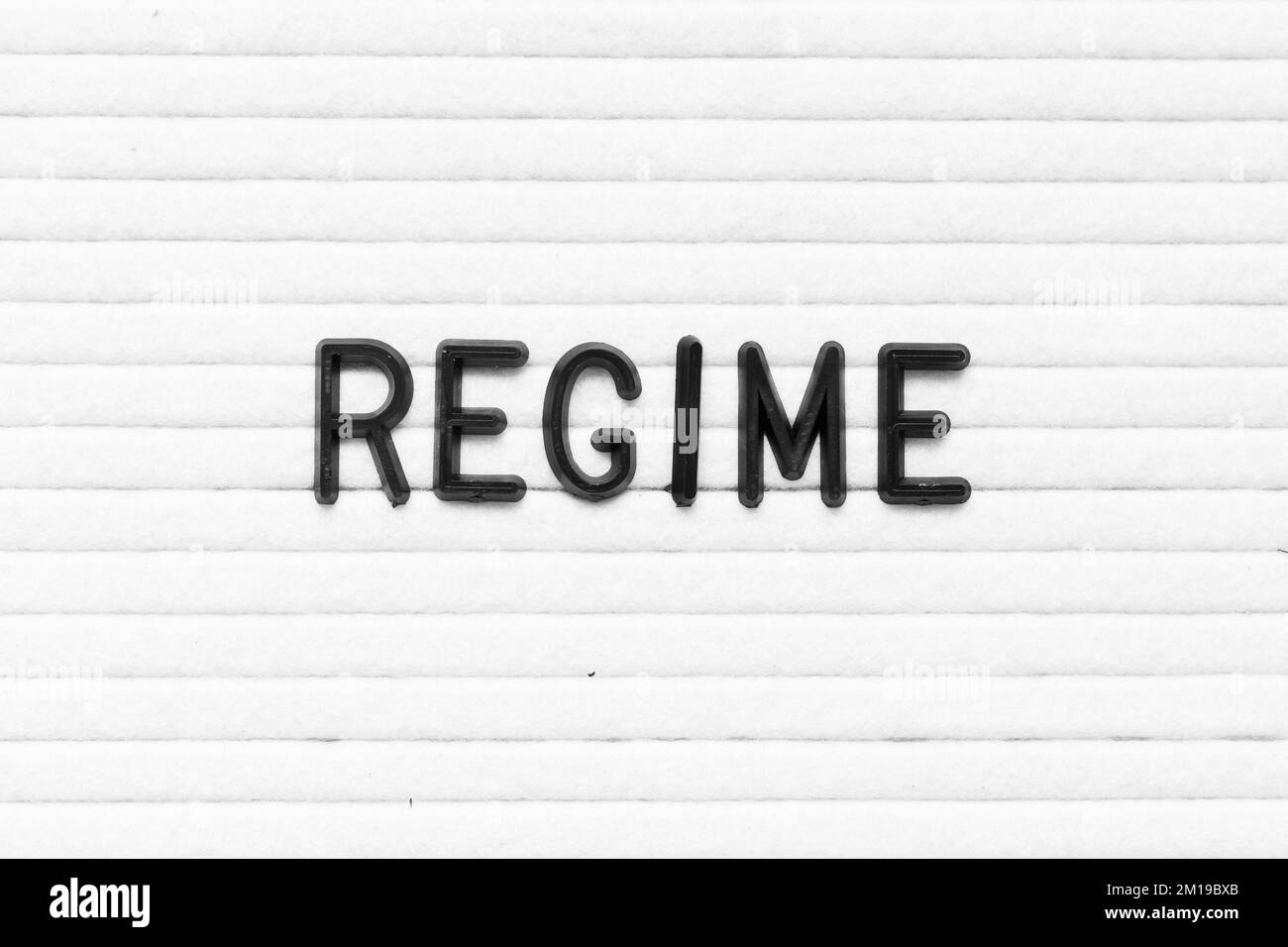 Black color letter in word regime on white felt board background Stock ...