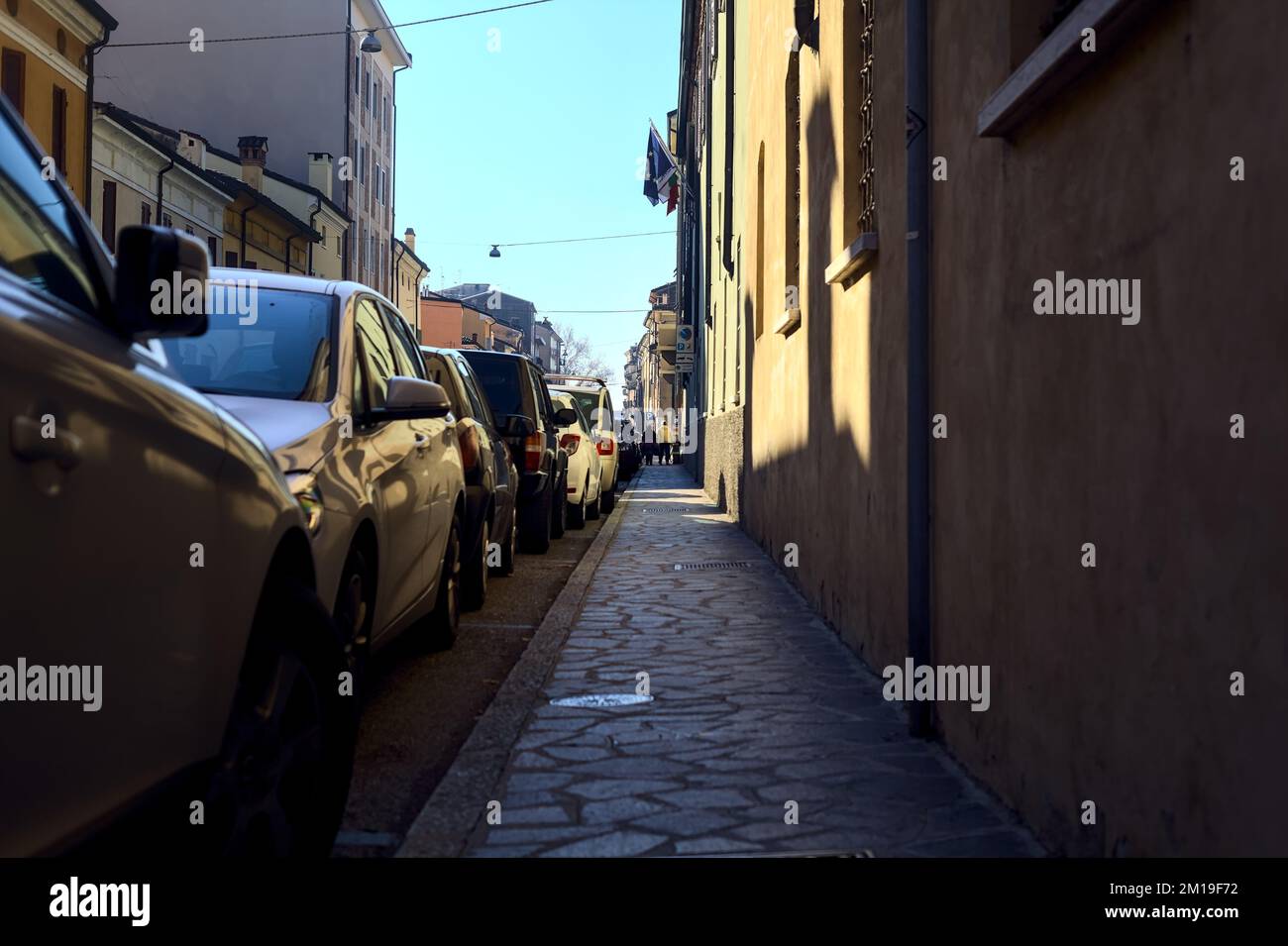 Pavement between parked cars and a building Stock Photo - Alamy