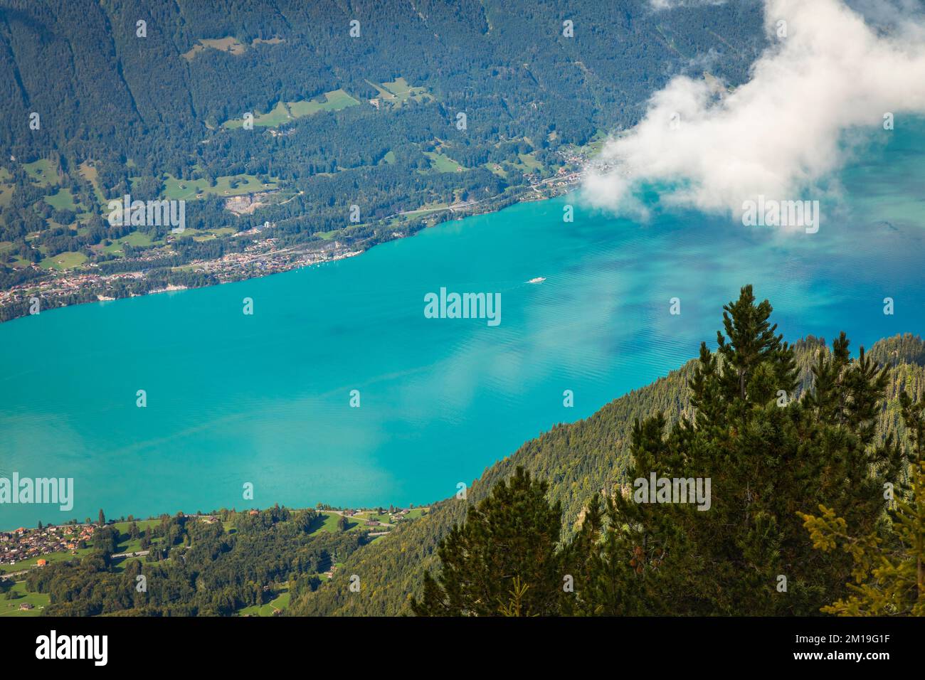 Aerial view of Swiss Alps and Lake Brienz with ferry boat at sunset ...