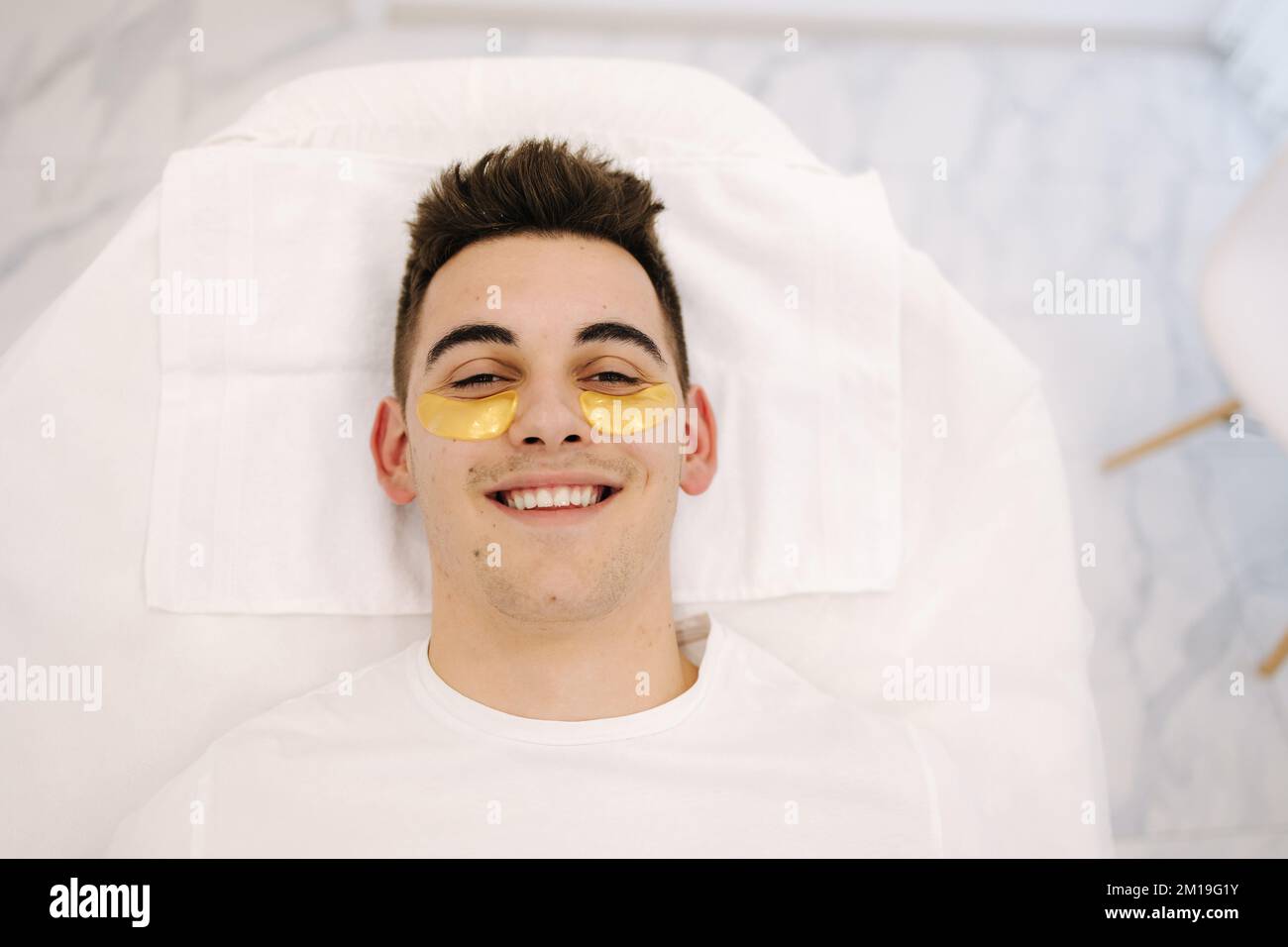 Handsome man with golden patch under eyes. Beauty studio. Spa salon ...