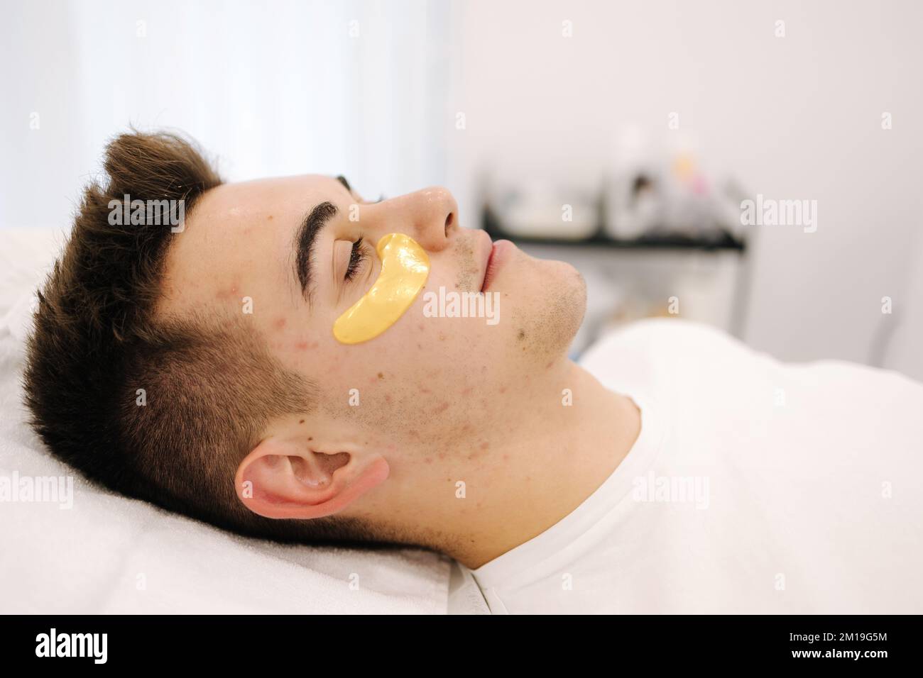 Side view of handsome man with golden patch under eyes. Beauty studio ...