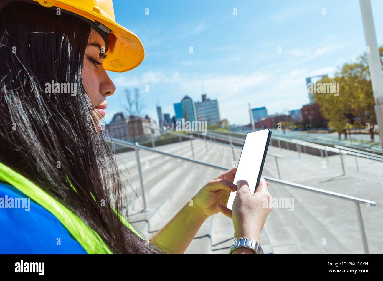 young caucasian female engineer, wearing yellow safety helmet and vest ...