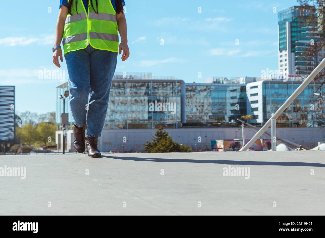 front view woman in safety vest and blue clothes, unrecognizable from ...