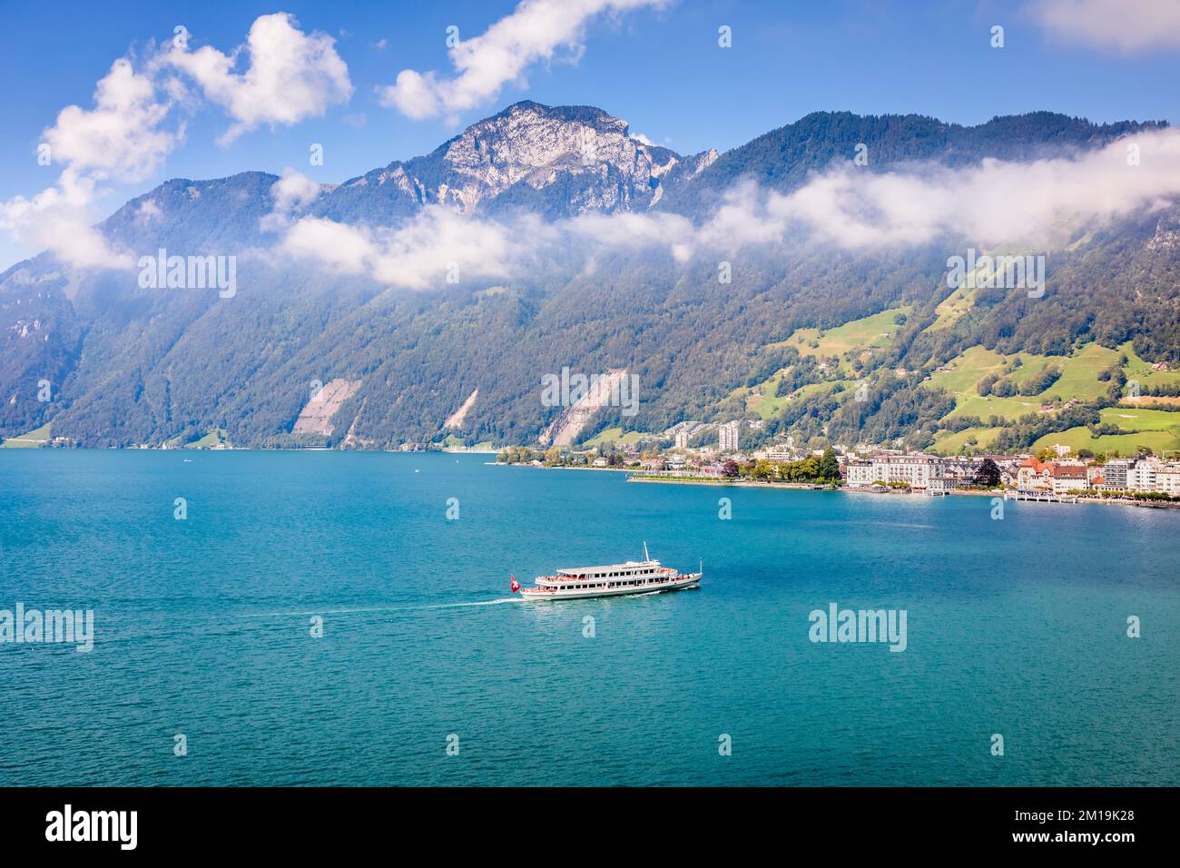 Swiss alps and lake Lucerne with ferry boat arriving at harbor ...