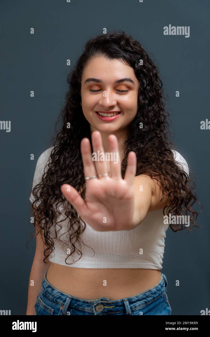 Vertical portrait of young beautiful woman making stop sign with hand ...