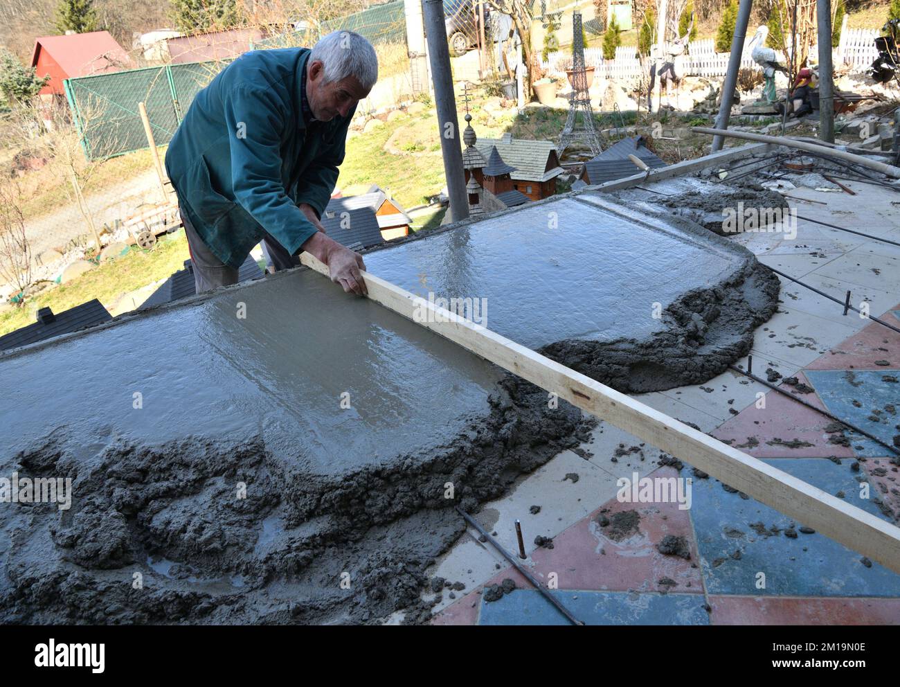 The mason balances freshly poured concrete into the flat surface Stock ...