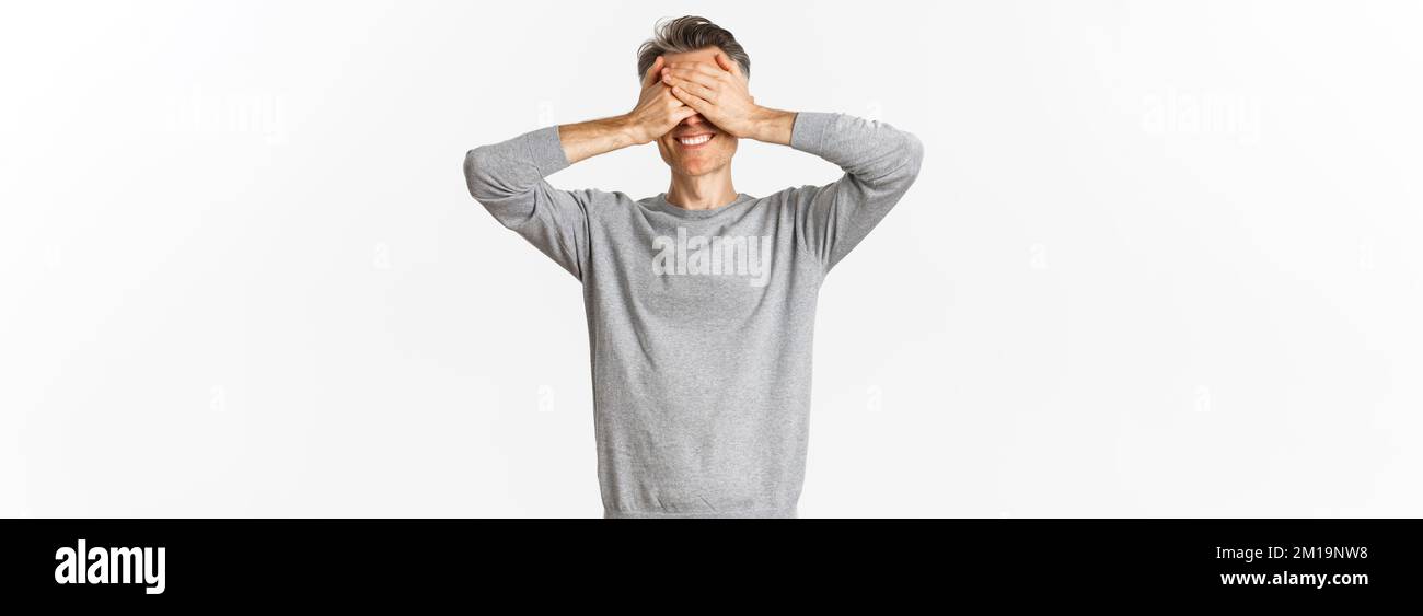 Portrait of handsome happy middle-aged man waiting for surprise, shut ...