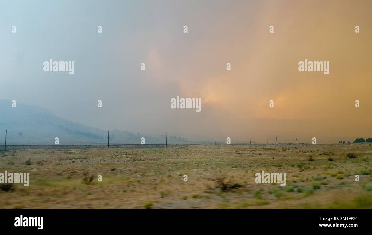 Escaping a smoky wildfire seen in the distance Stock Photo - Alamy