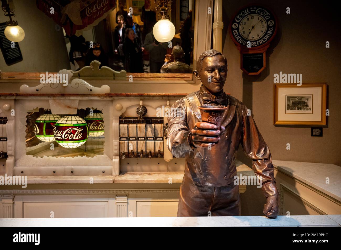 A statue of a man handing a Coca Cola drink to a customer Stock Photo ...