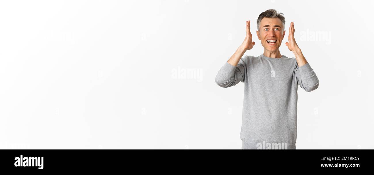 Image of frustrated middle-aged guy in grey sweater panicking, shaking ...