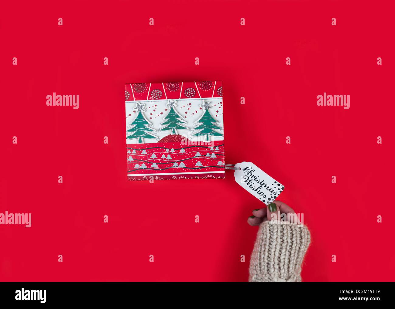 Female hands in white wolen sweater holding present box with green ...