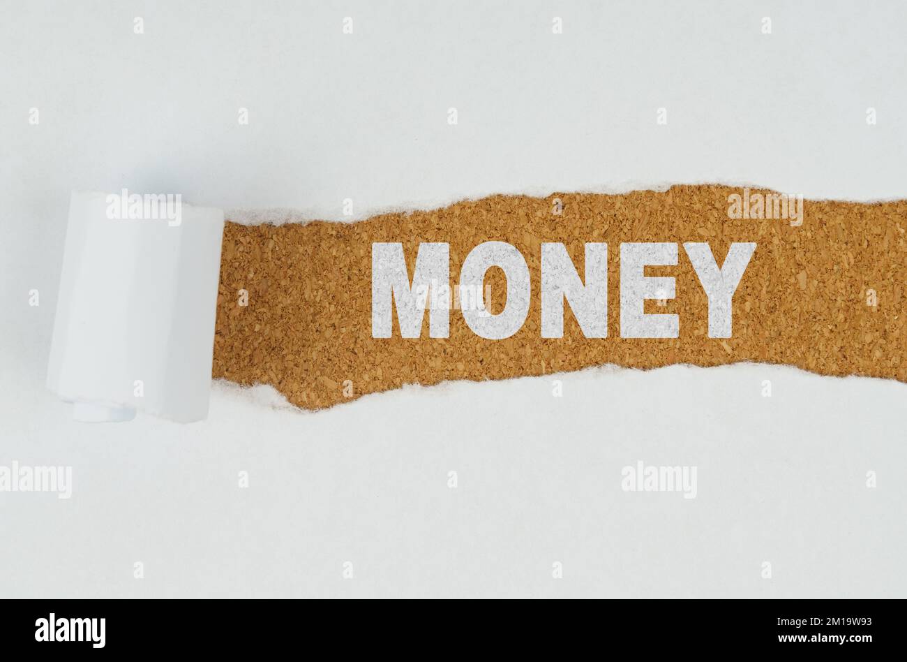 Business and finance. Behind torn white paper on a wooden background ...