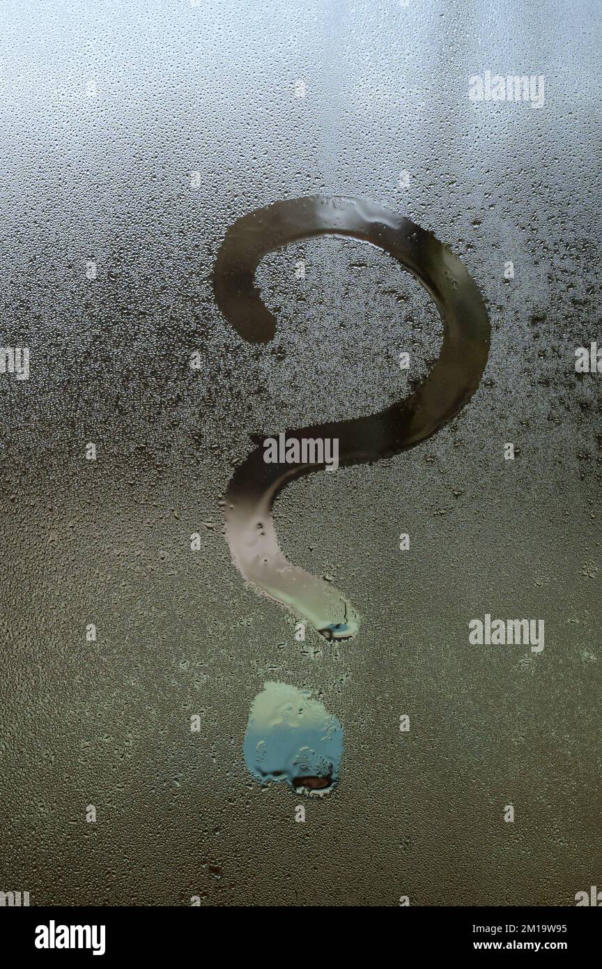 A question mark is drawn on glass with condensation, the effect of ...