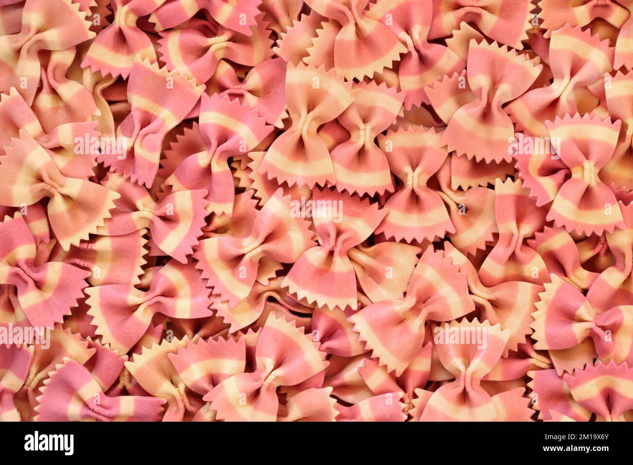 Farfalle bow tie Italian pasta background. Beetroot food dye used for ...
