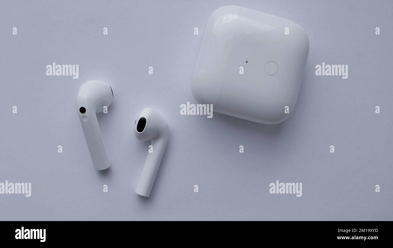 wireless headphones with a square charging case made of white plastic ...