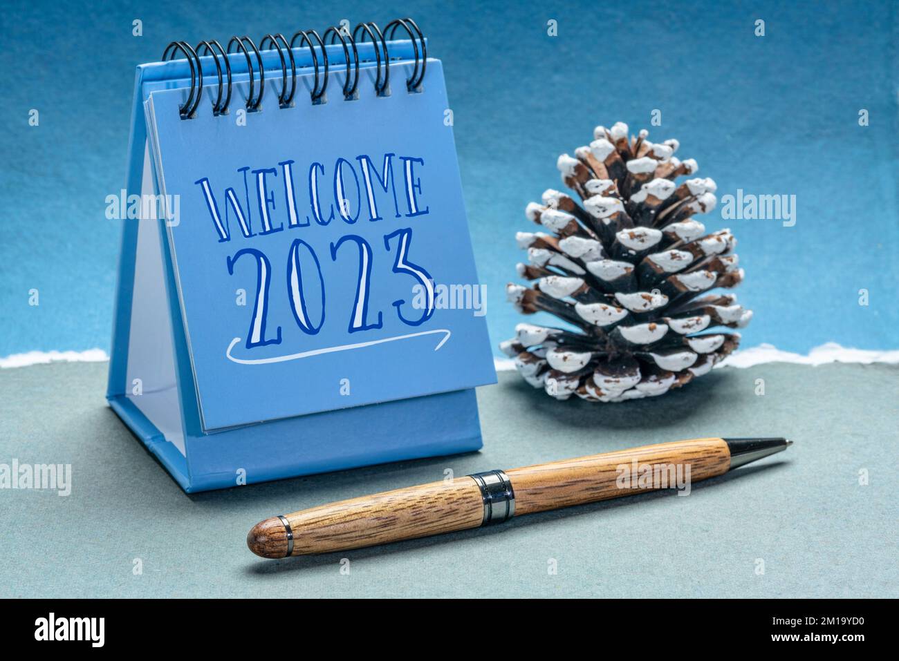 welcome 2023 in a spiral desktop calendar with a decorative frosty pine ...