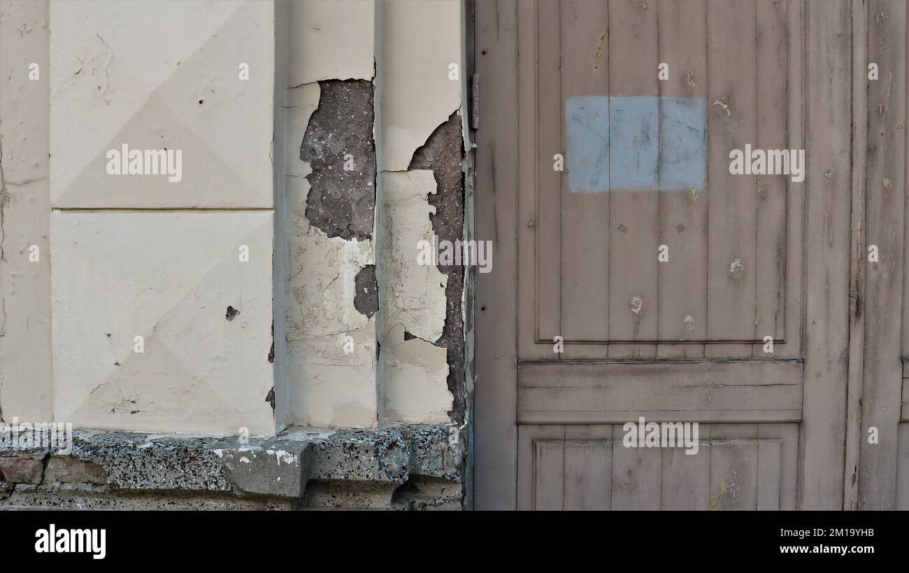 cracked and flaky corner of a city building with cracks and wooden old ...