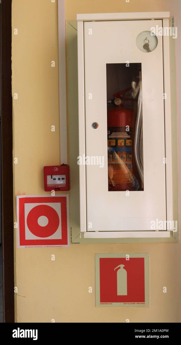 fire hydrant in a white cabinet on the wall with fire extinguisher ...