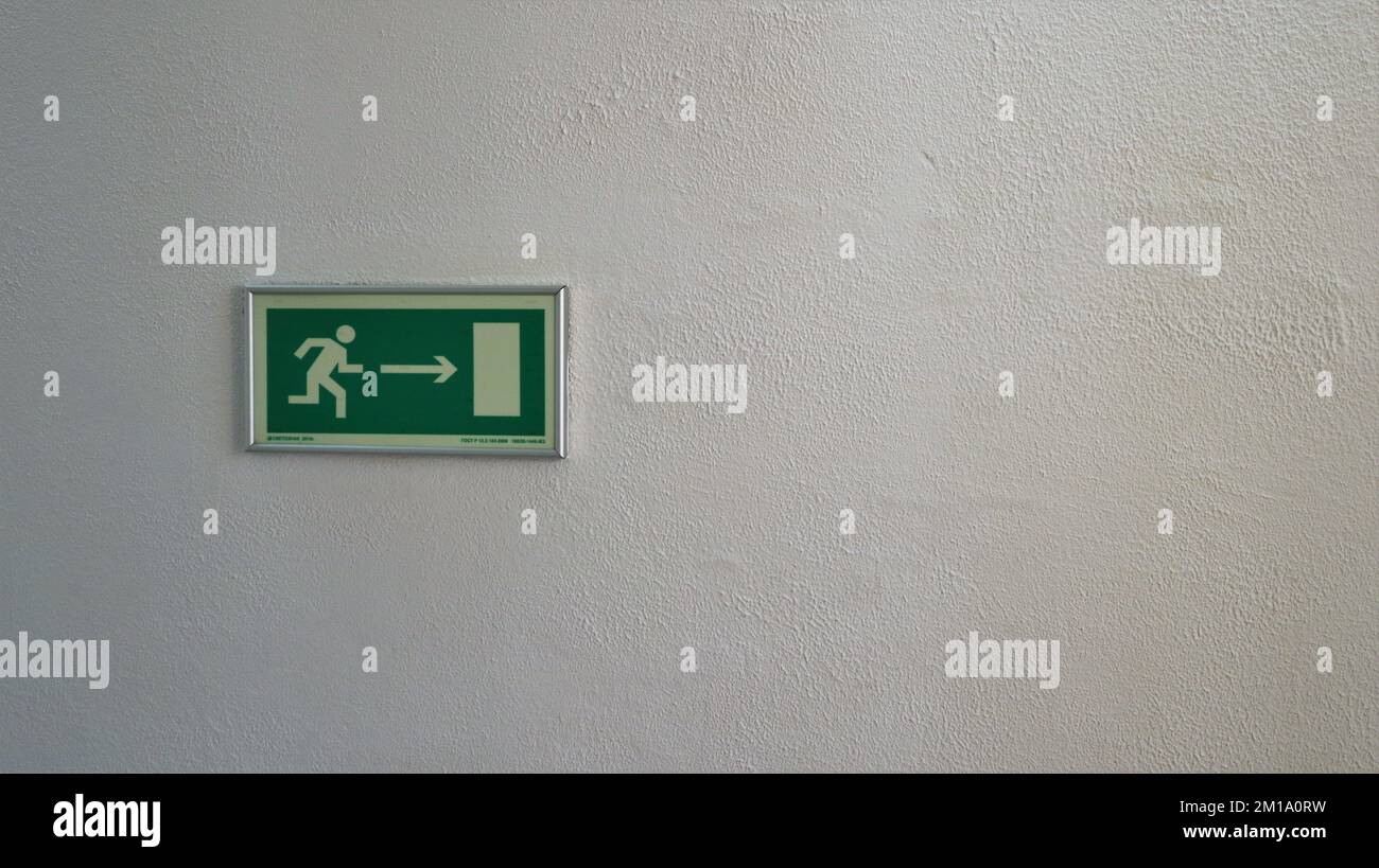 green emergency exit sign in case of evacuation from the building in ...