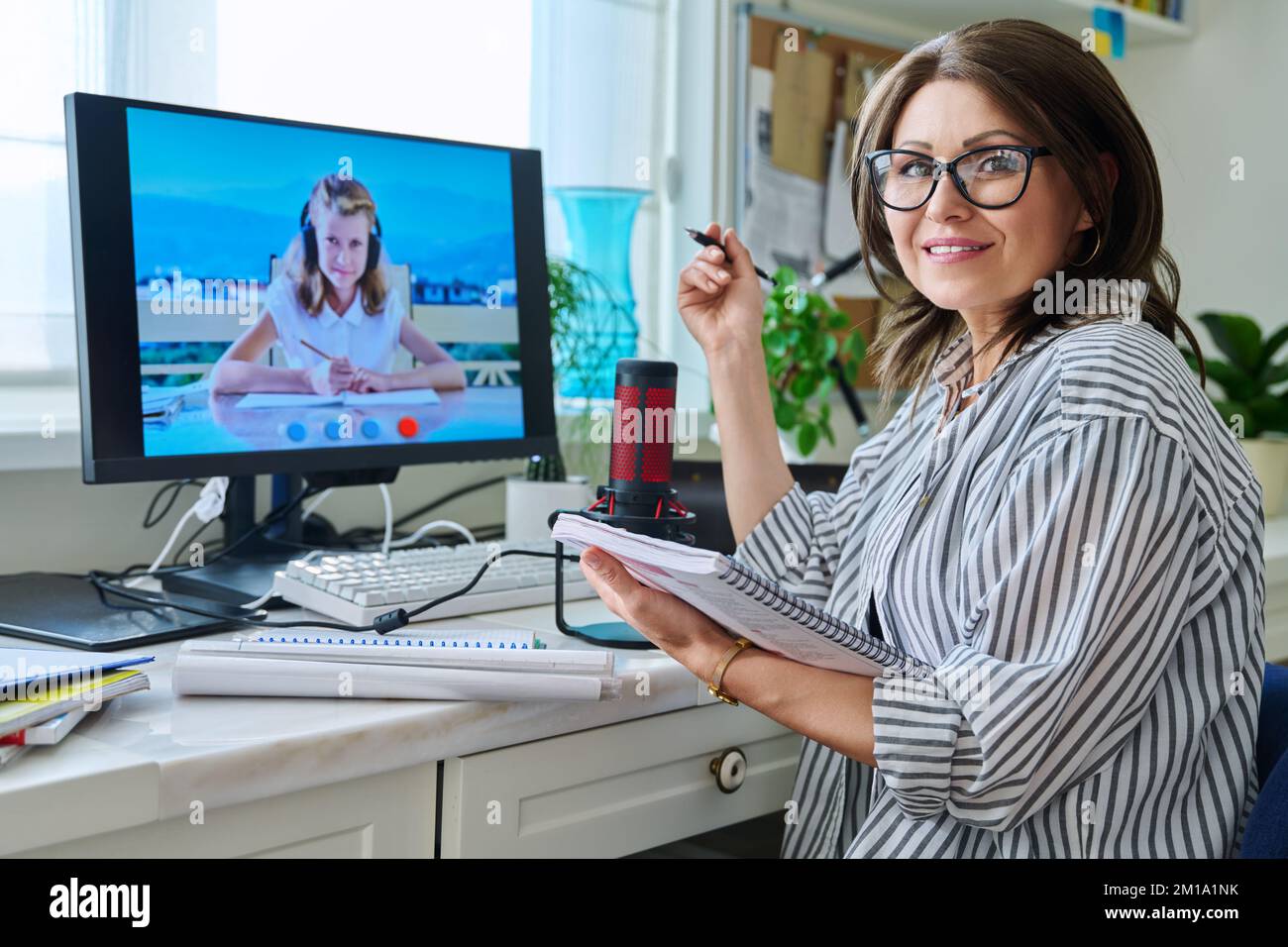 Online lesson, woman teacher teaching child girl Stock Photo - Alamy