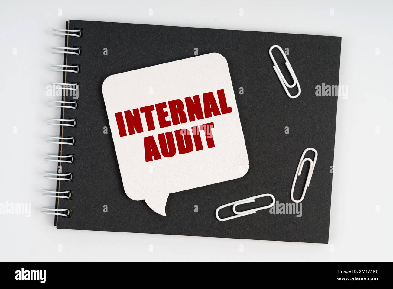 Business concept. On the notebook are white paper clips and a sign with ...