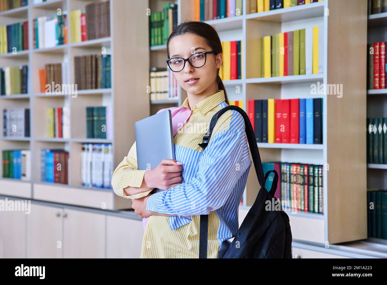 Portrait of teenager student girl looking at camera in library Stock ...