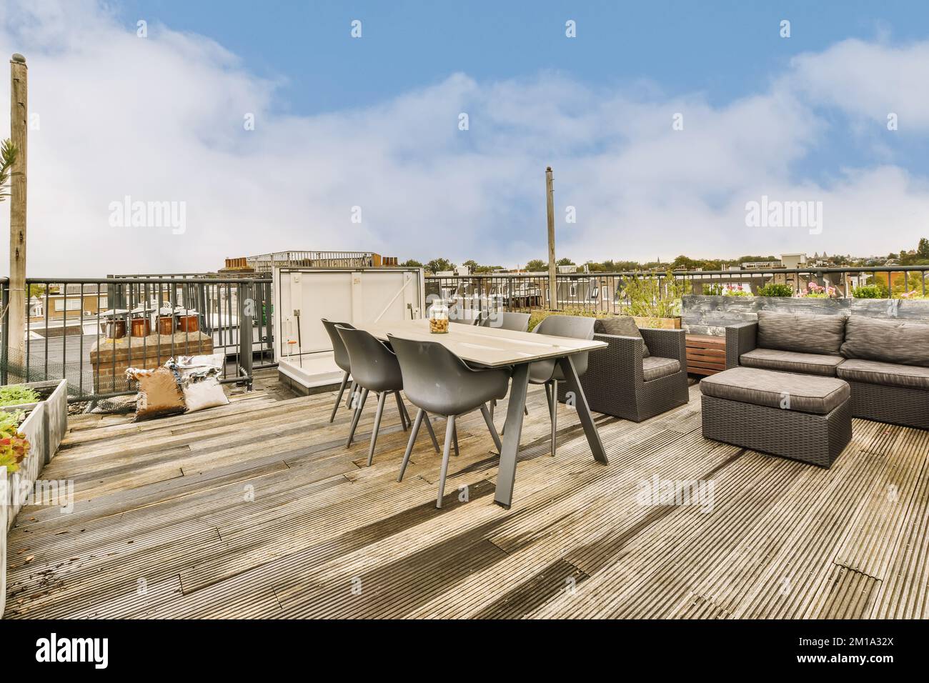 an outdoor living area with wood flooring and white clouds in the blue ...