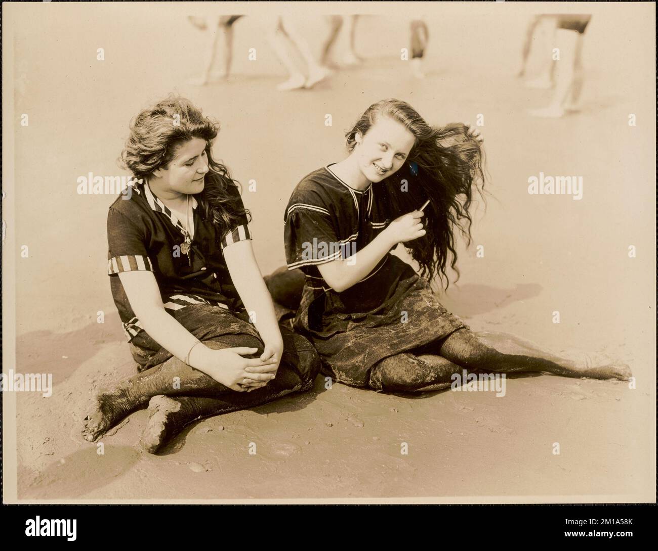 Two women on a beach, one combing her hair , Beaches, Grooming. Leon ...