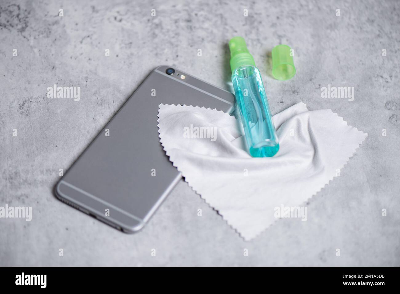 Cleaning the smartphone with soft cloth and alcohol. COVID-19 ...