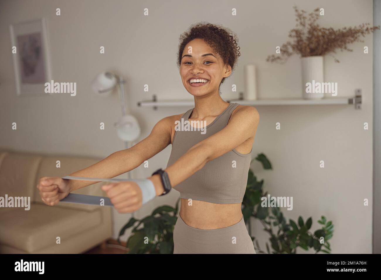 Slim woman doing exercises for hands with elastic band by online ...