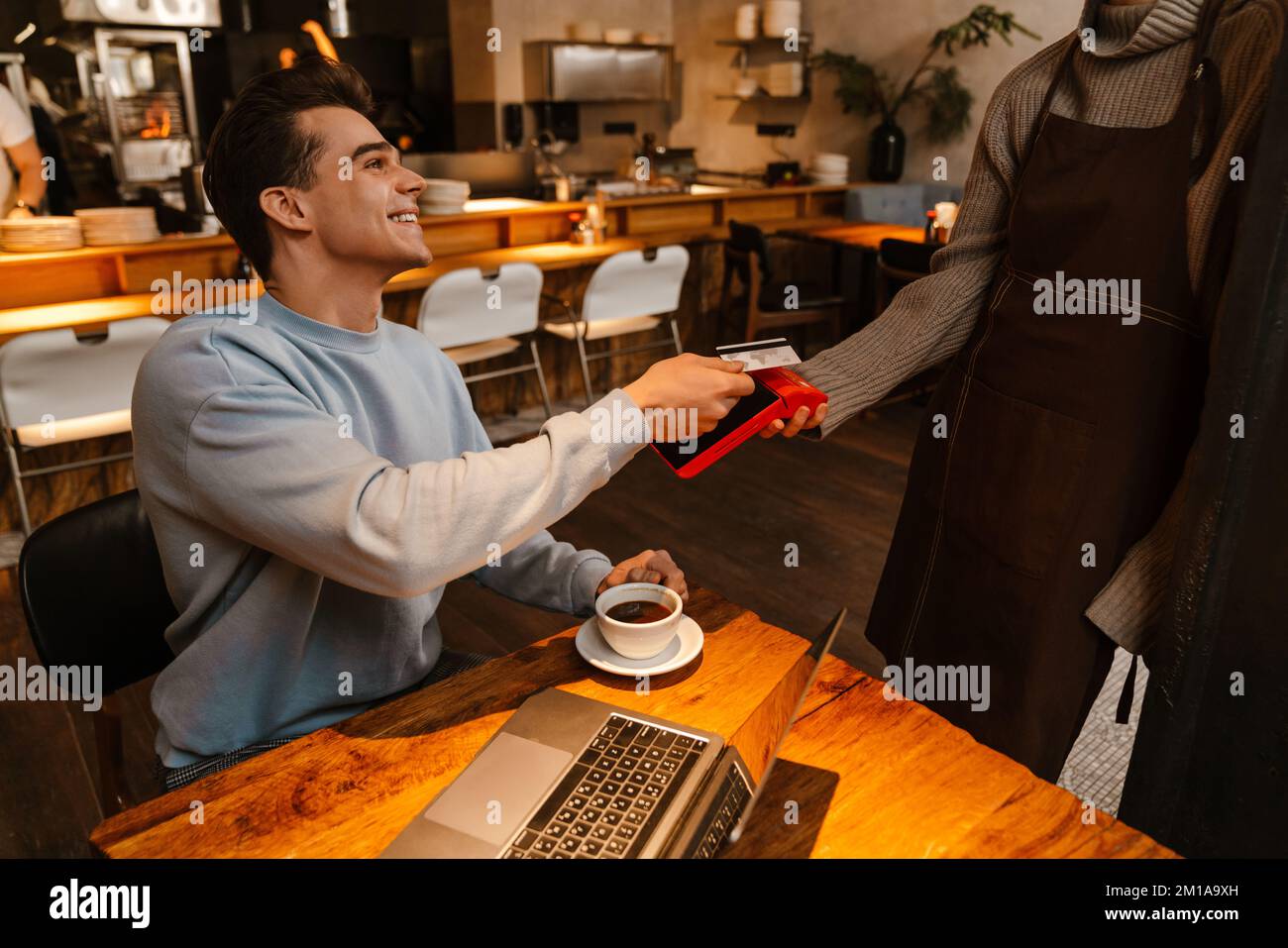 Young happy white man smiling while paying for his order with credit ...