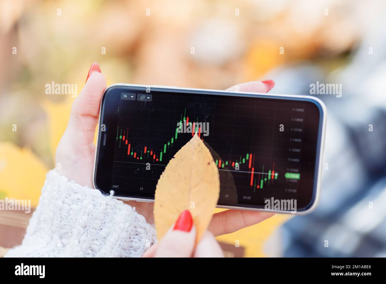Bitcoin graph in red and green on the phone. beautiful girl sits on the ...