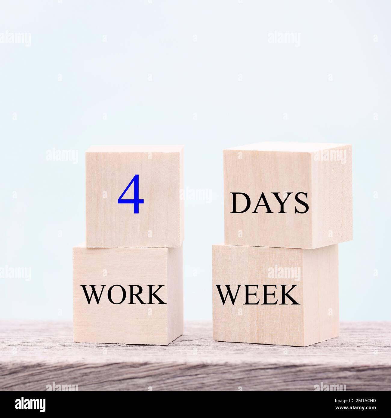 4 day working week words on wooden cube on blue background. reducing ...