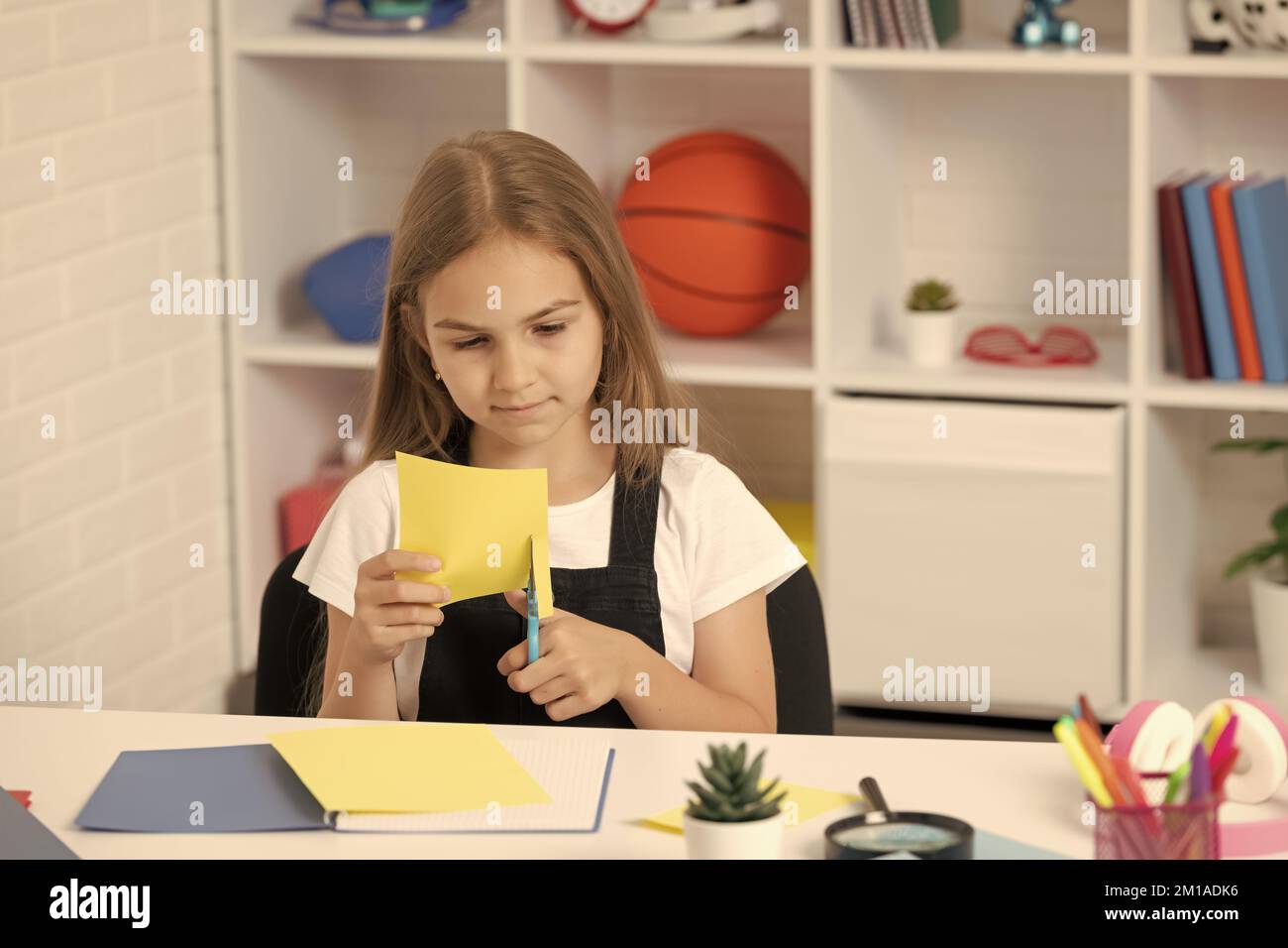 concentrated child cut paper in school classroom Stock Photo - Alamy