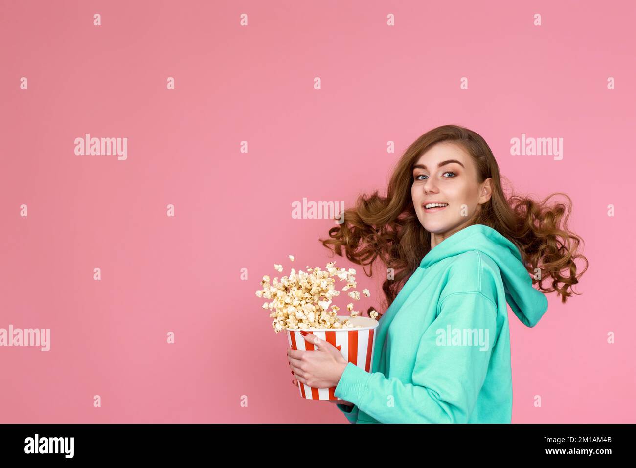 woman holding bucket of popcorn and jumping Stock Photo - Alamy