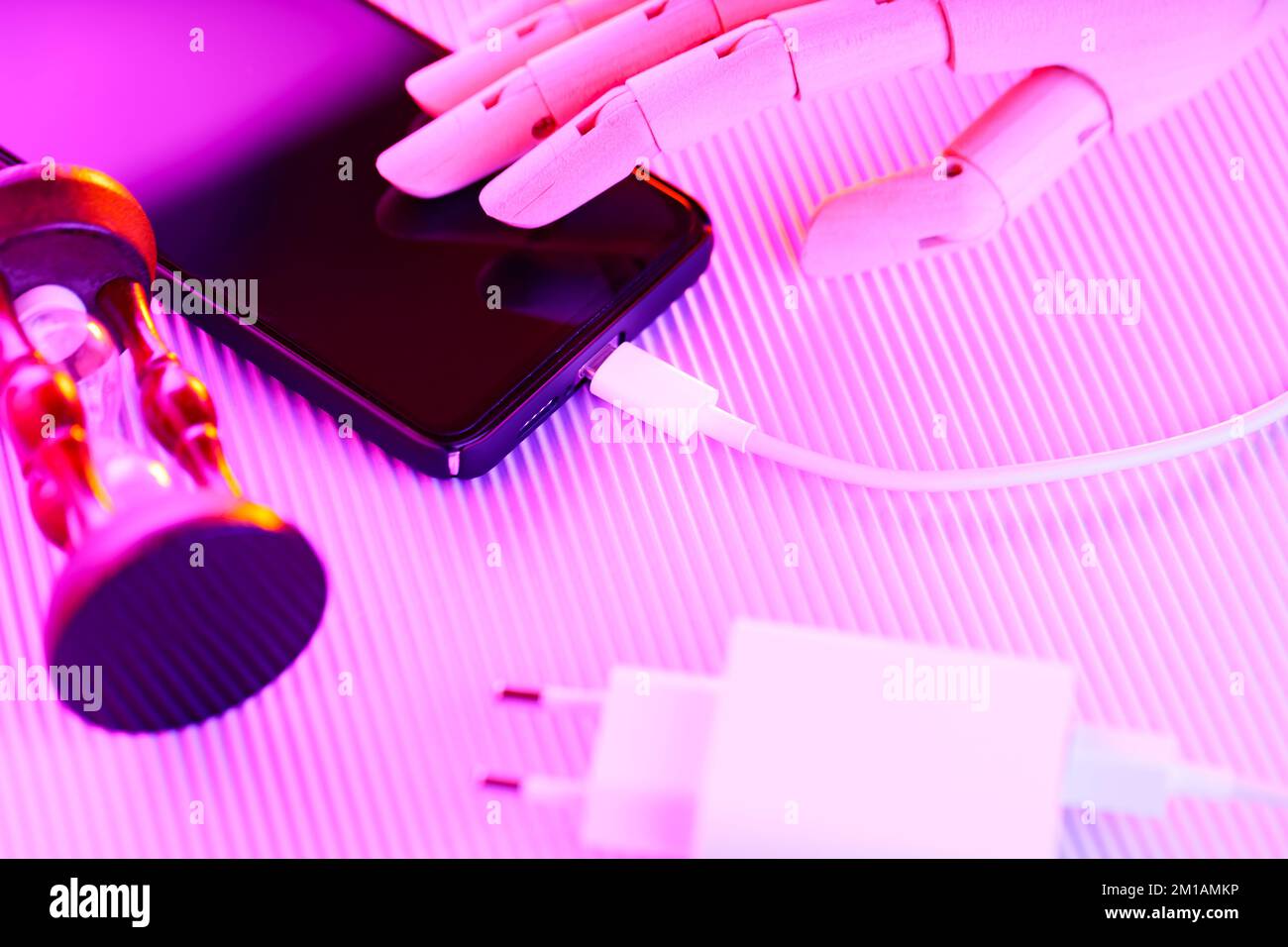 Smartphone charging artificial hand. Mobile phone with connected plug ...