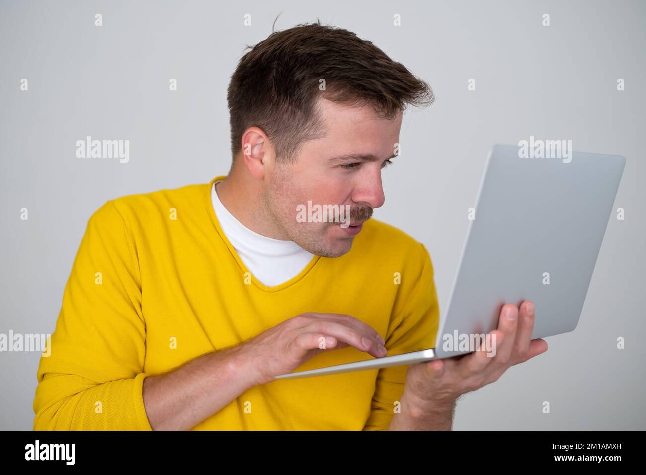 Thoughtful focused clever interested freelancer holding laptop with ...