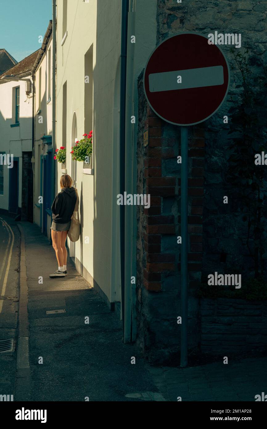 A beautiful view of a street sign and a female standing in the street ...