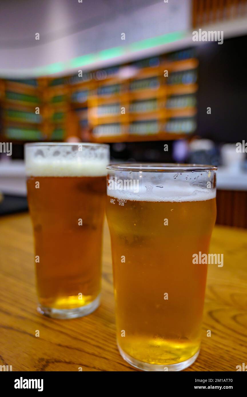 Fresh draught lager or IPA beer is glass served in indoor cafe close up ...
