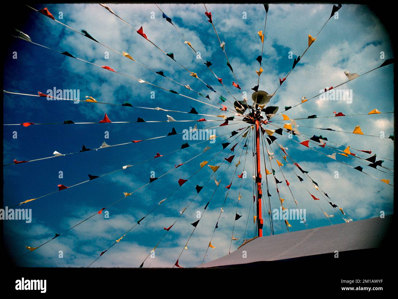 View looking up past roof to pole with radiating lines of pennants ...