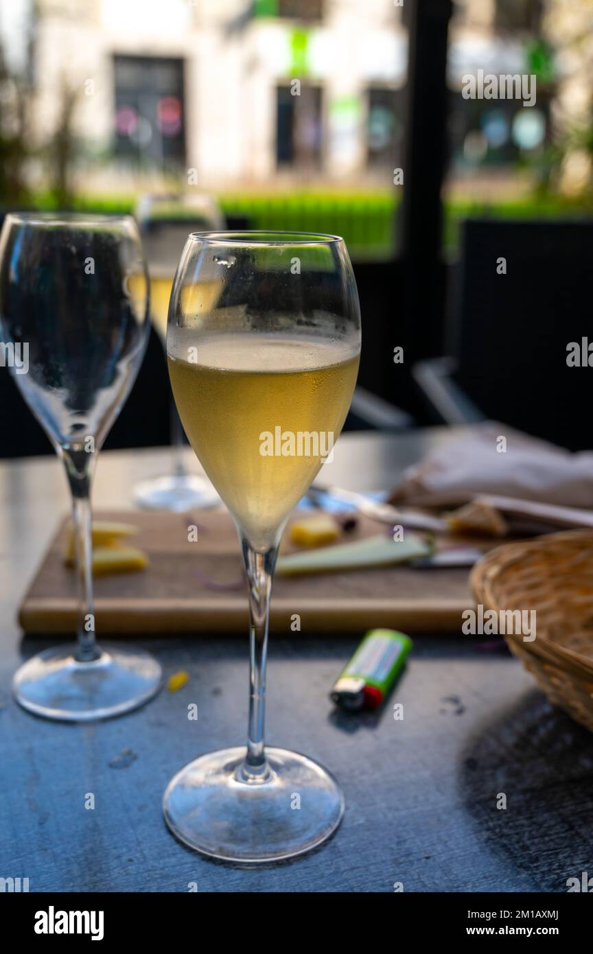 Tasting of white brut sparkling champagne wine outdoor in cafe in Reims ...