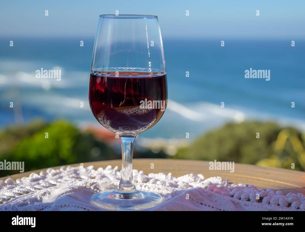 Tasting of tawny porto wine and view on sandy beach and blue Atlantic ...