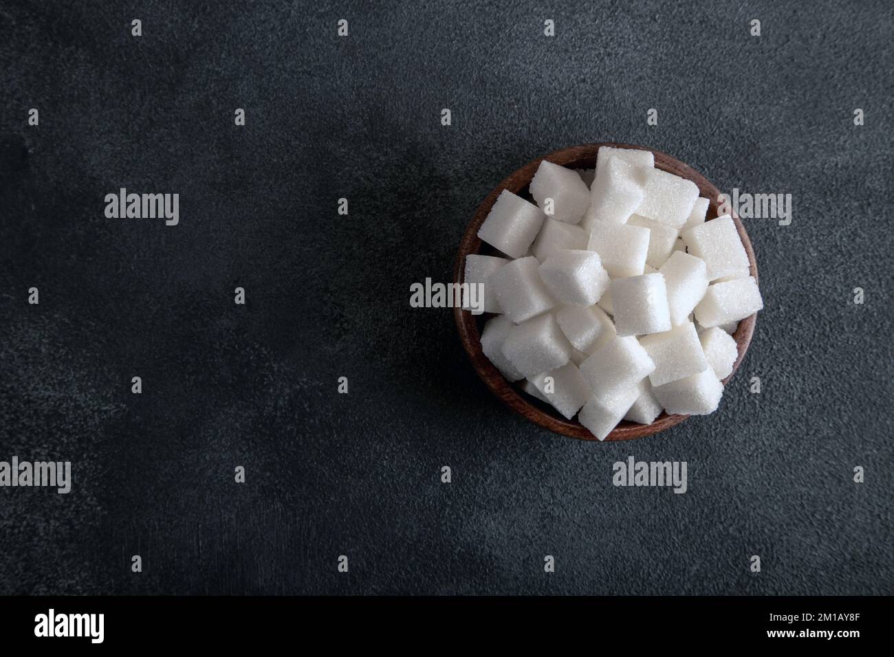 White sugar cubes in bowl on a dark background Stock Photo - Alamy