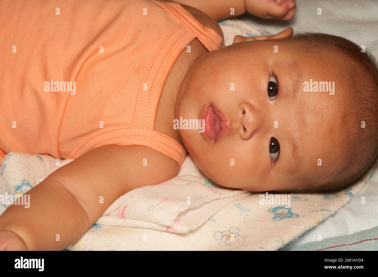 Newborn Asian baby girl lying and happiness on a bed Stock Photo - Alamy